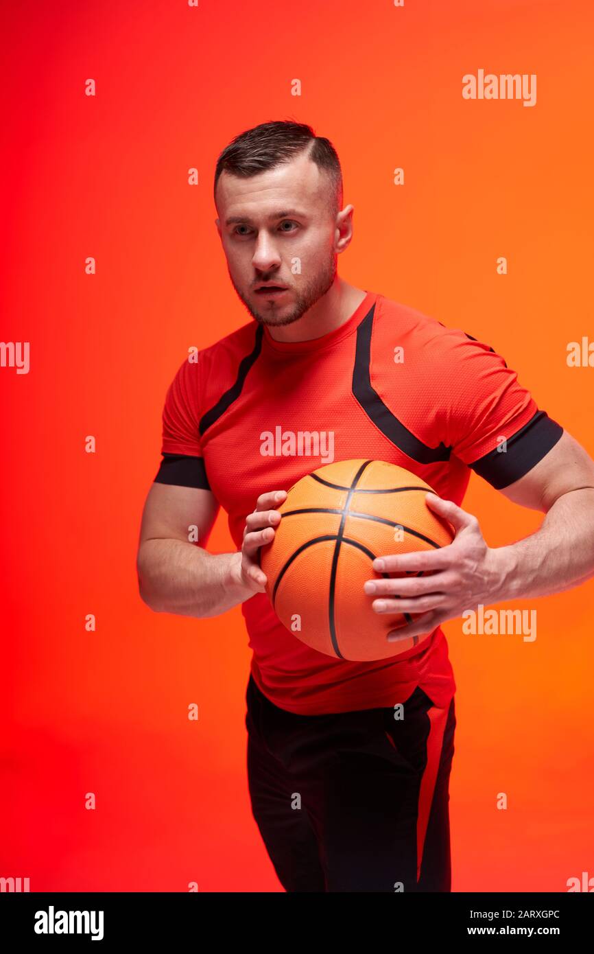 Young athletic basketball player in attack position holding ball with ...