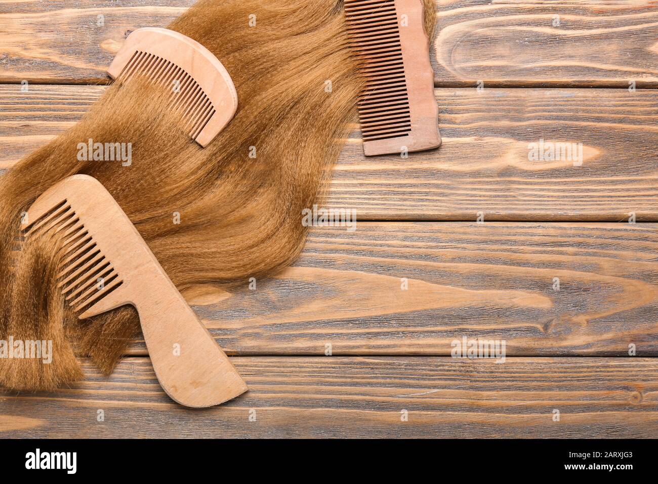 Hair strand and combs on wooden background Stock Photo - Alamy
