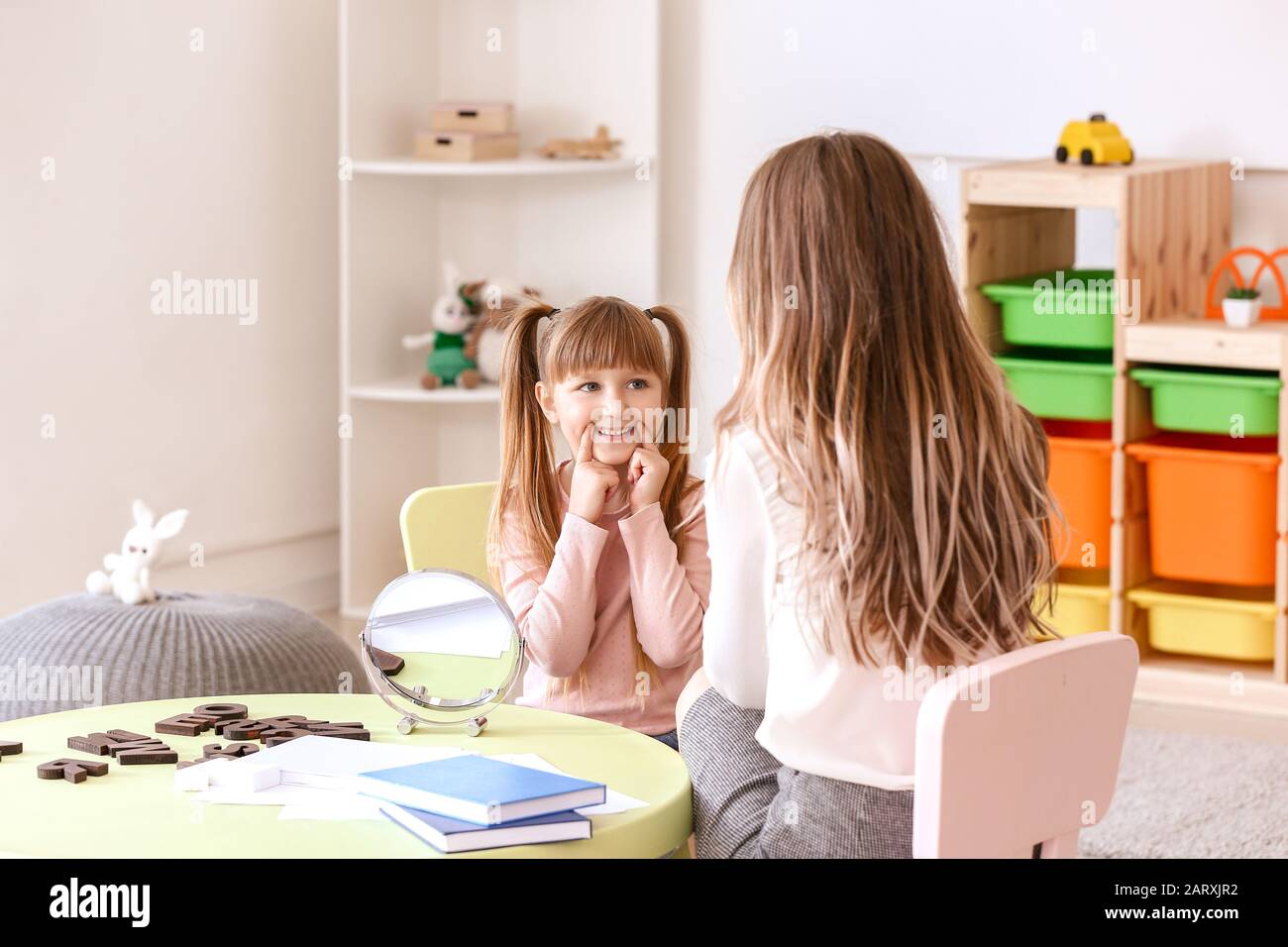 Cute little girl at speech therapist office Stock Photo - Alamy