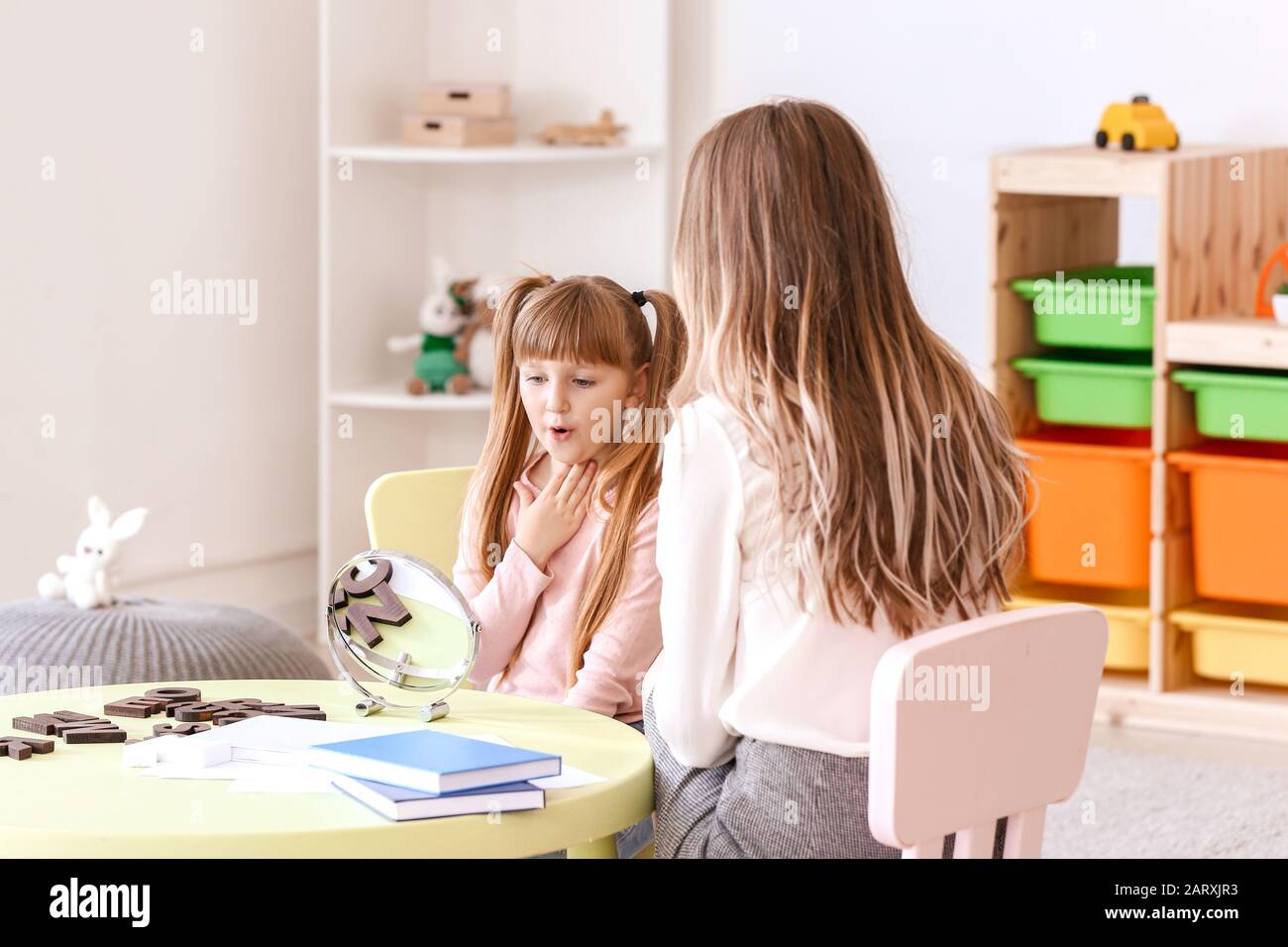 Cute little girl at speech therapist office Stock Photo - Alamy