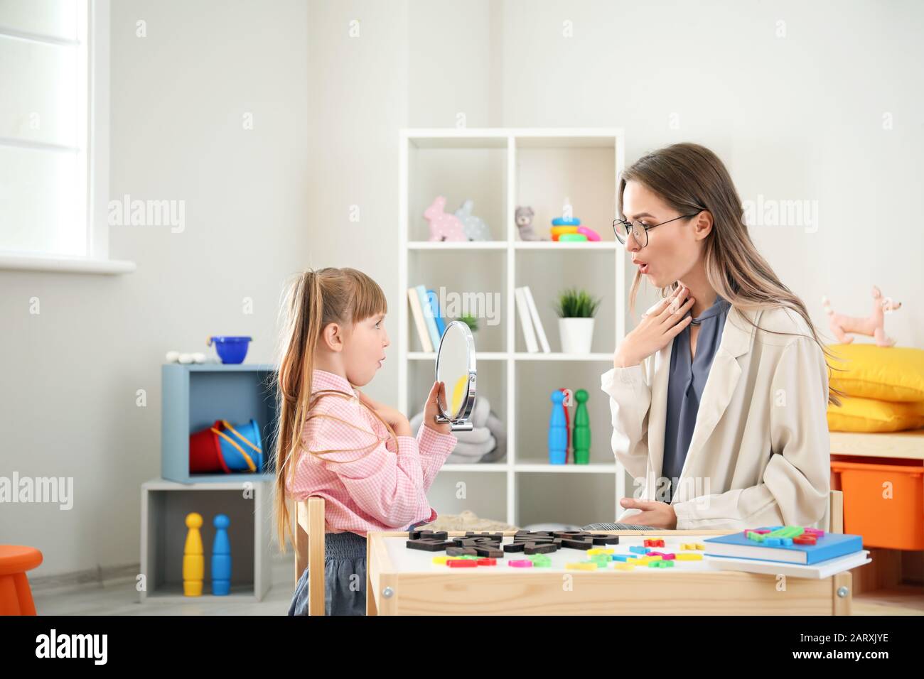 Cute little girl at speech therapist office Stock Photo - Alamy