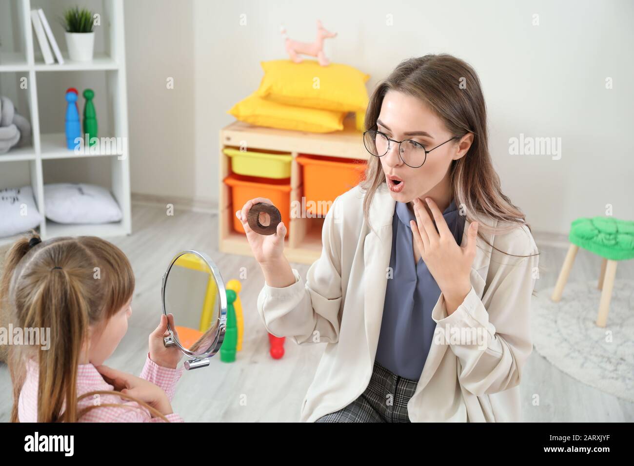 Cute little girl at speech therapist office Stock Photo - Alamy