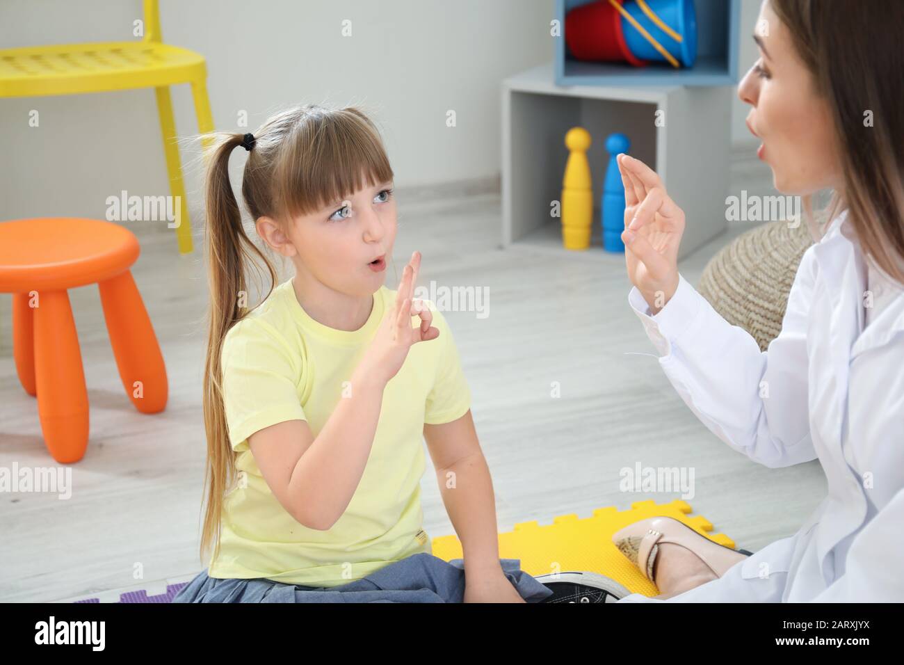 Cute little girl at speech therapist office Stock Photo - Alamy