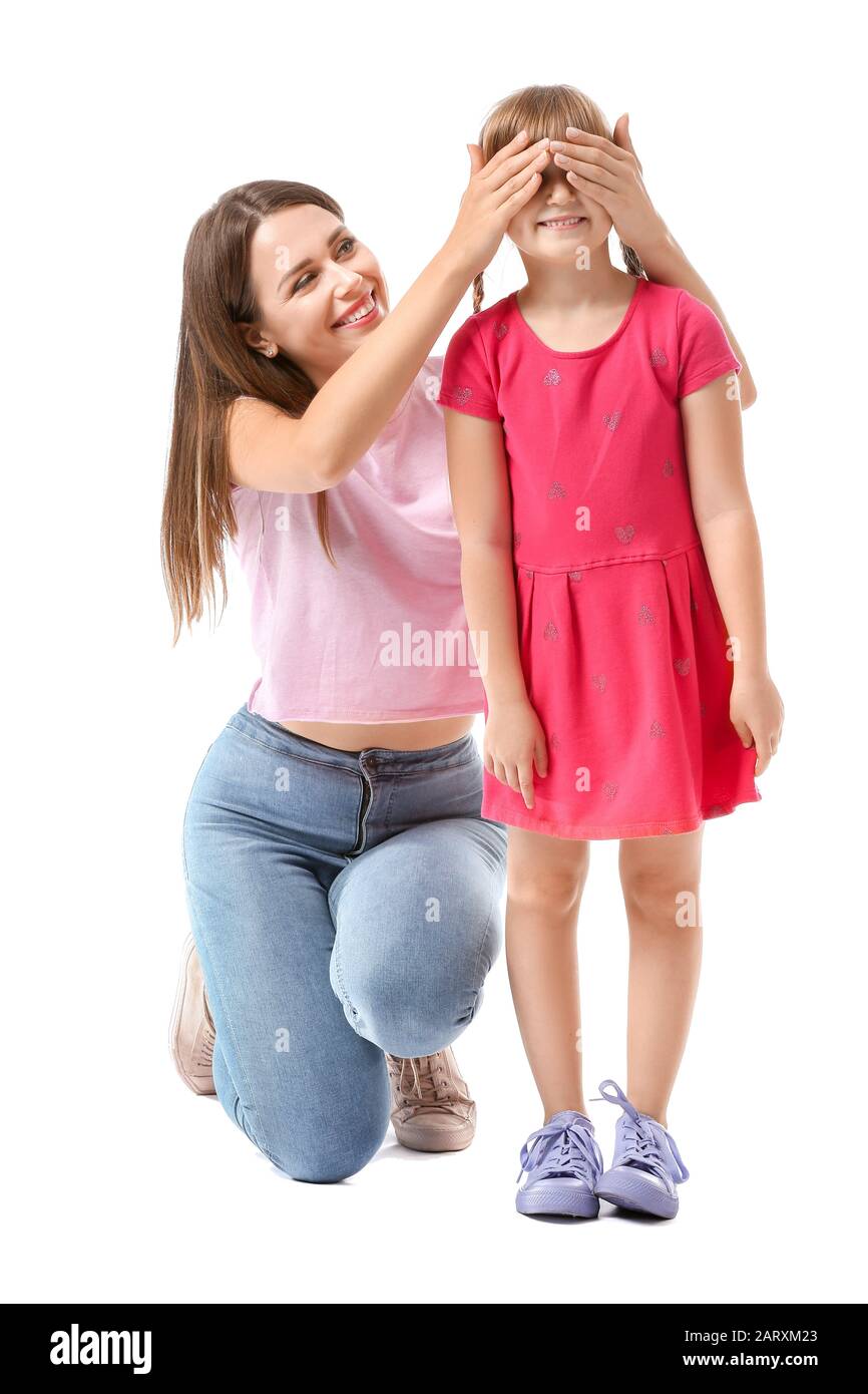 Happy mother covering eyes of her little daughter on white background ...