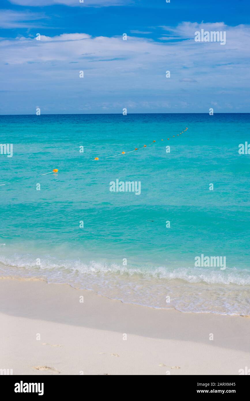 White and red round marker buoys rope floating in a sea, marking an end ...