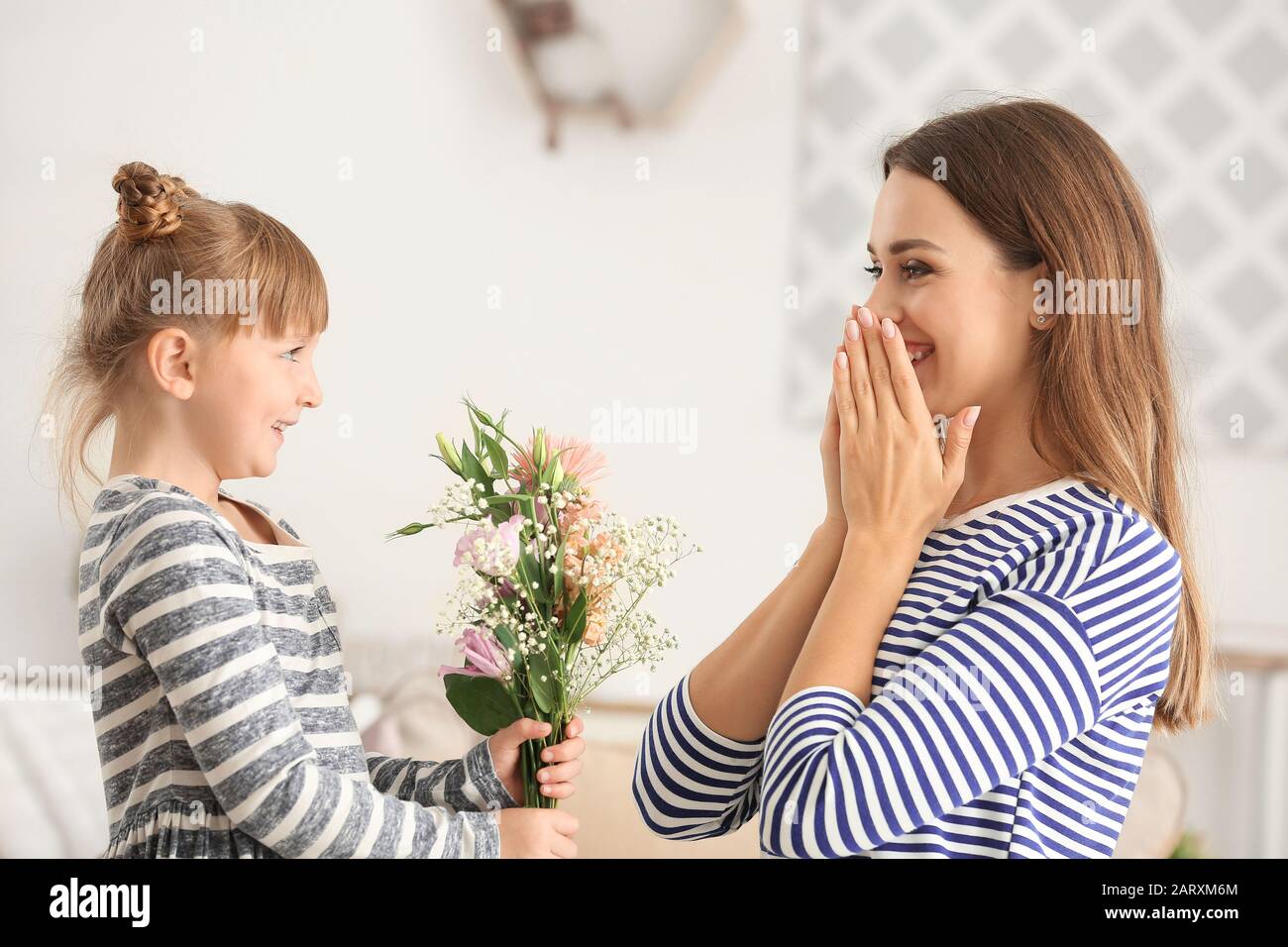 Little girl greeting her mother at home Stock Photo - Alamy