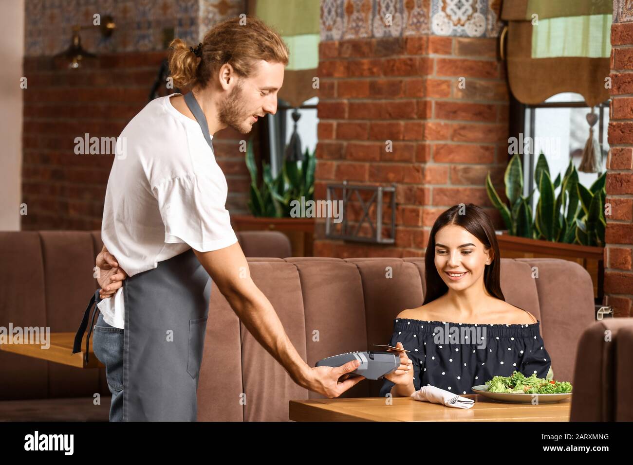 Woman paying bill in restaurant through terminal Stock Photo - Alamy