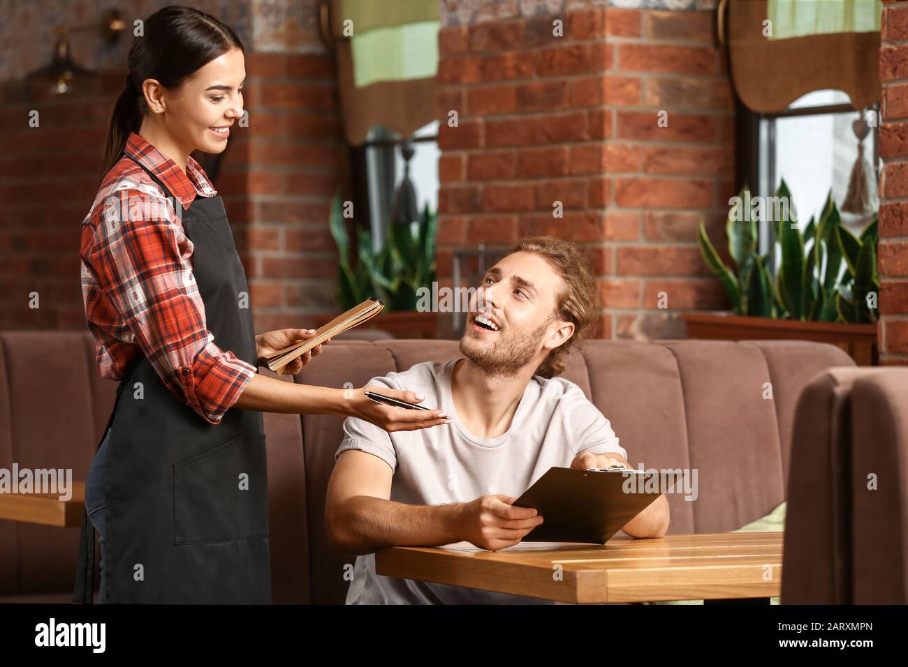 Waitress serving client in restaurant Stock Photo - Alamy