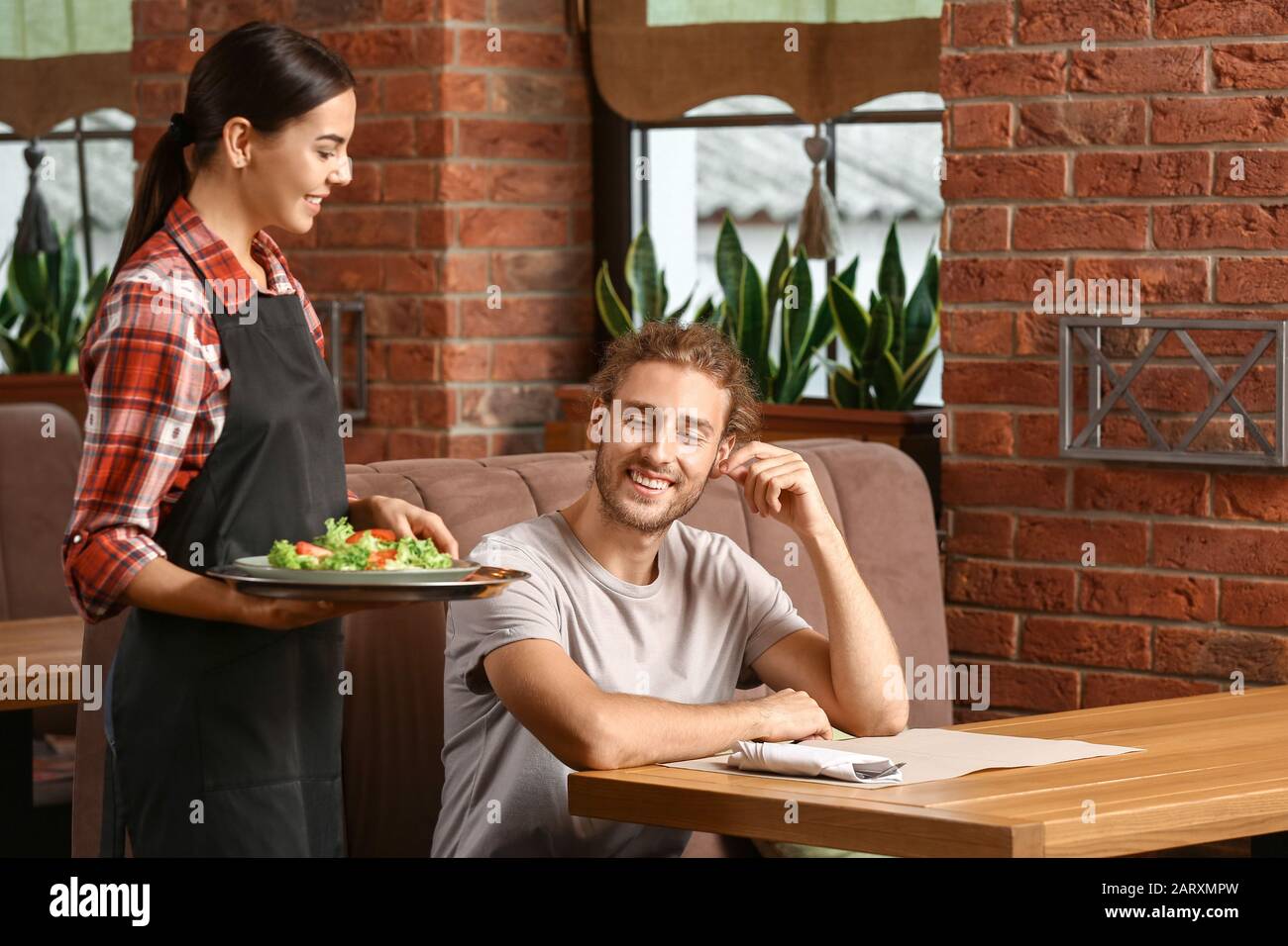 Waitress serving client in restaurant Stock Photo - Alamy