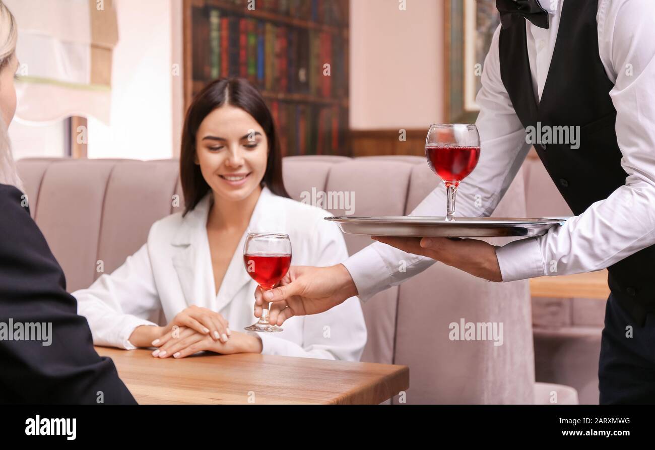 Waiter serving client in restaurant Stock Photo - Alamy