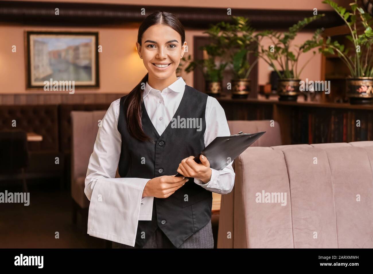 Portrait of young waitress in restaurant Stock Photo - Alamy