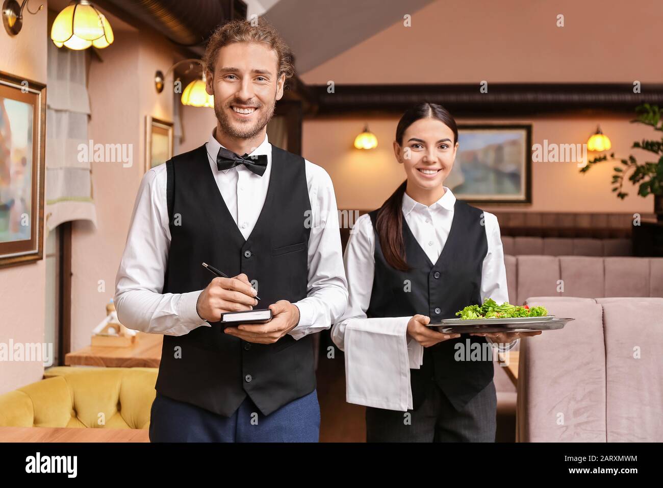 Portrait of young waiters in restaurant Stock Photo - Alamy