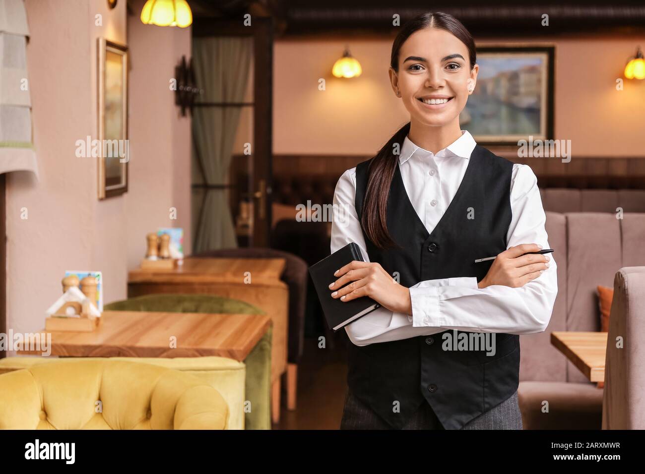Portrait of young waitress in restaurant Stock Photo - Alamy
