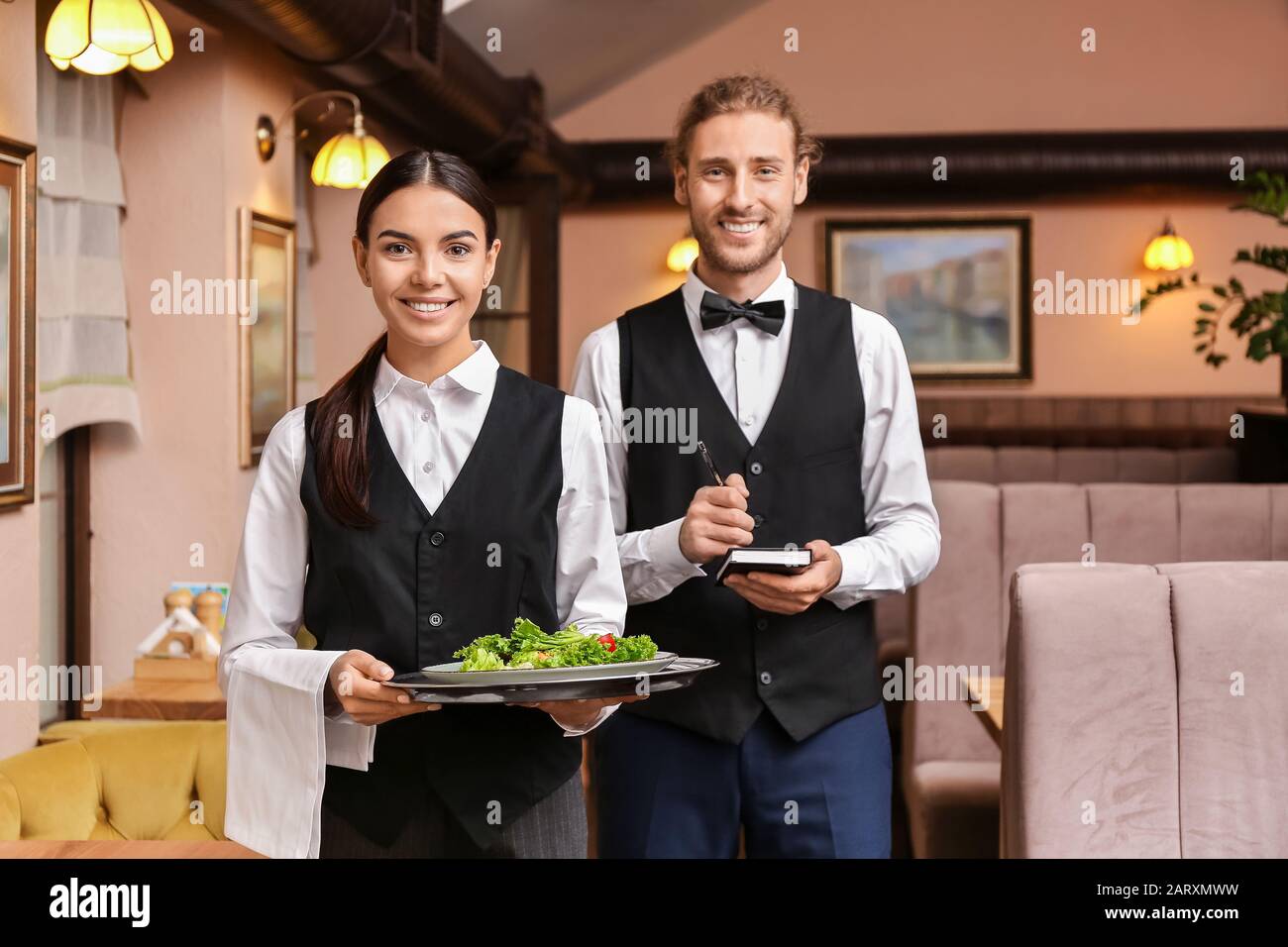 Portrait of young waiters in restaurant Stock Photo - Alamy