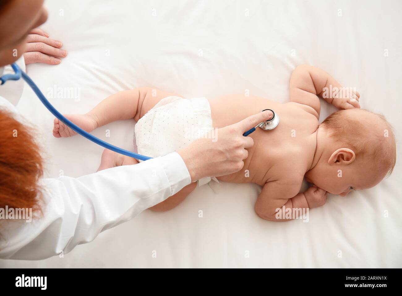 Pediatrician examining cute baby in clinic Stock Photo - Alamy