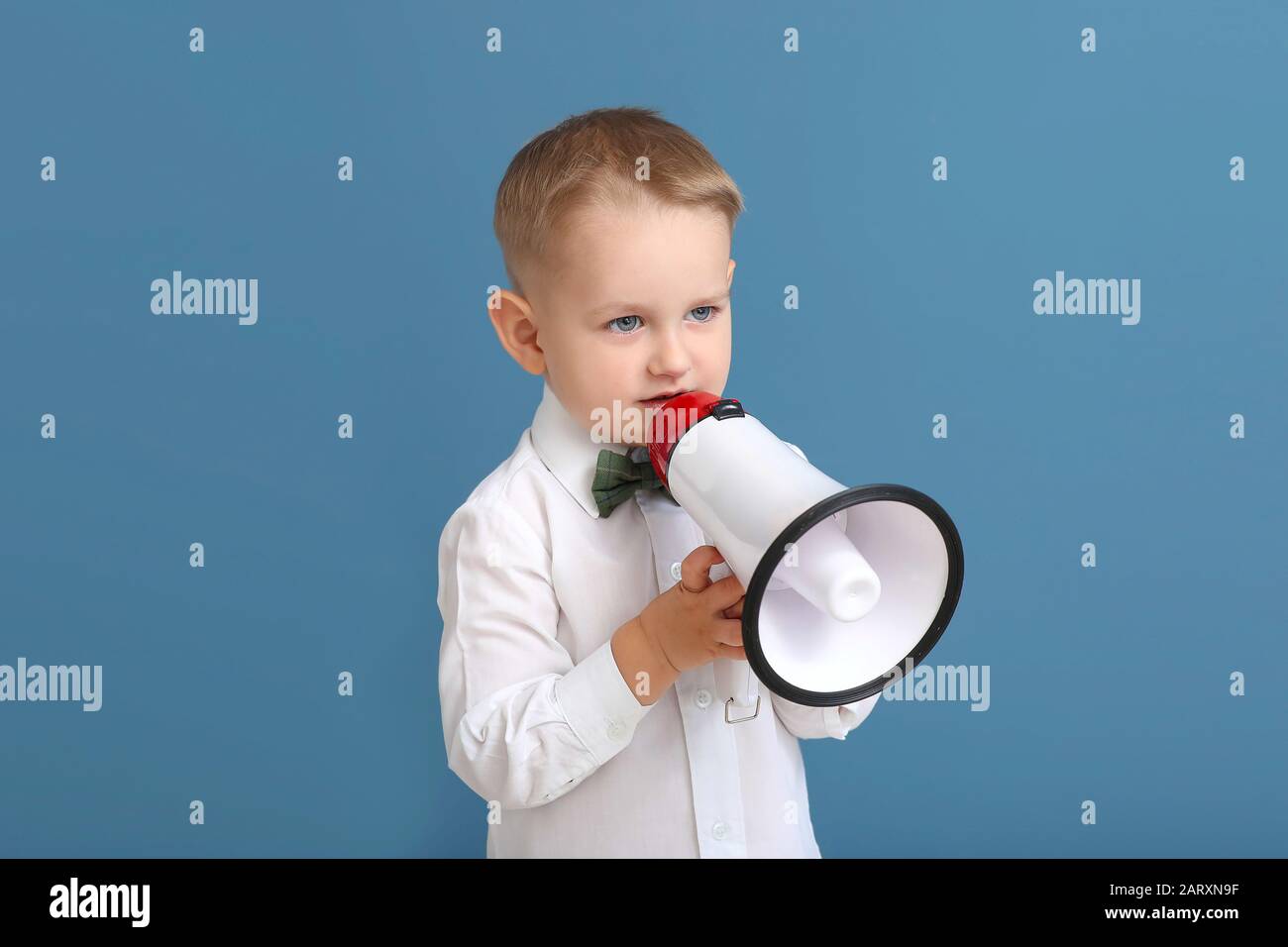 Portrait of cute little boy with megaphone on color background Stock ...