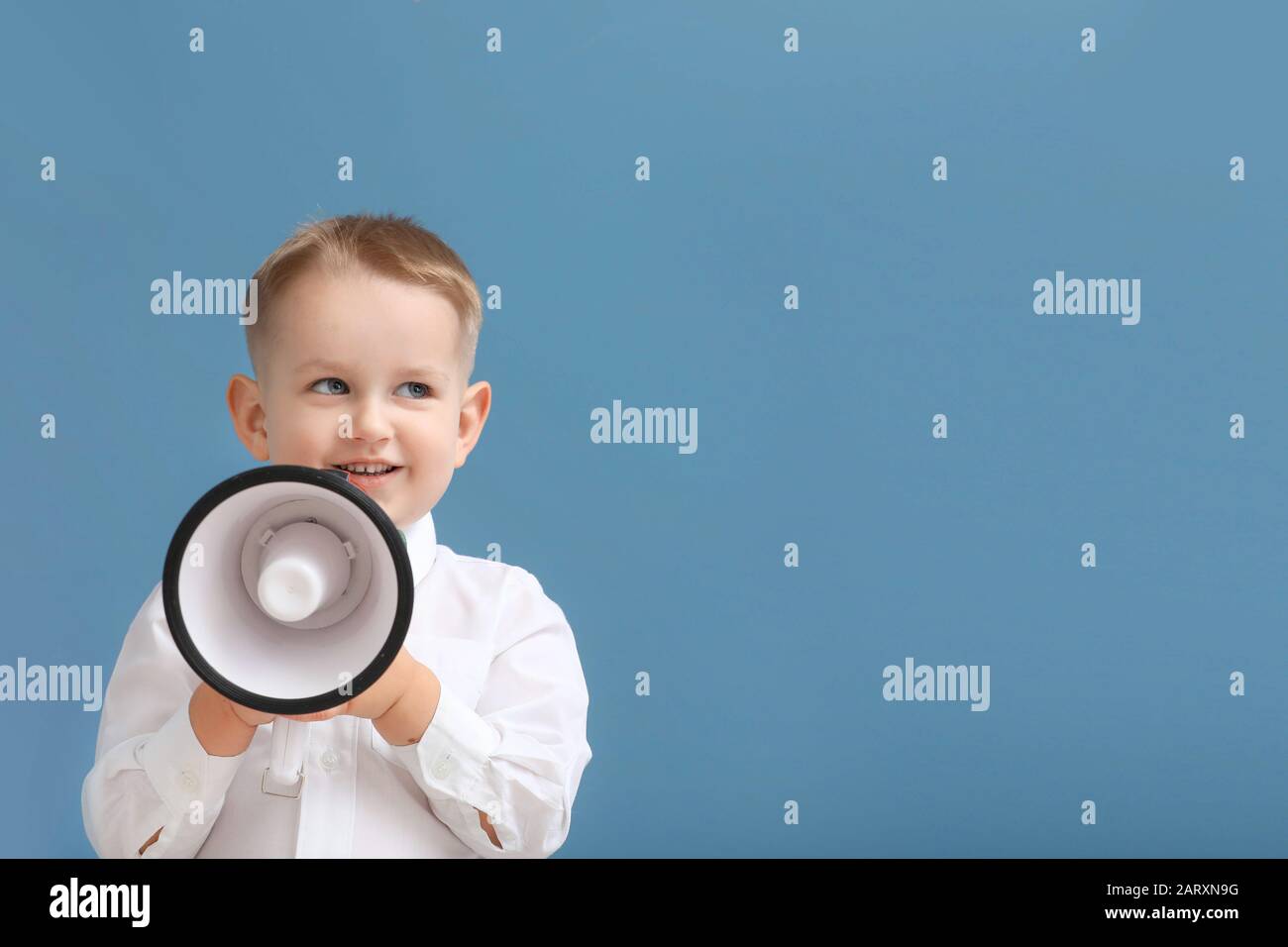 Portrait of cute little boy with megaphone on color background Stock ...