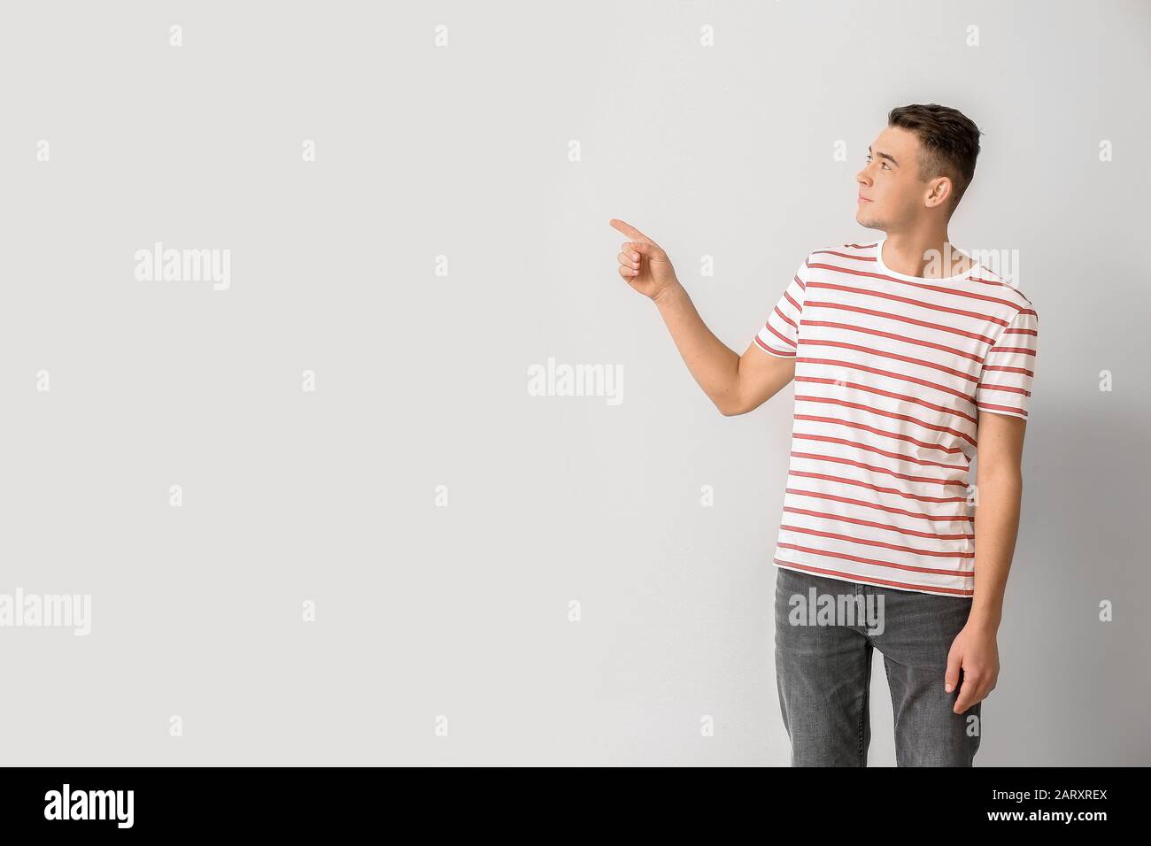Cool teenage boy pointing at something on white background Stock Photo ...