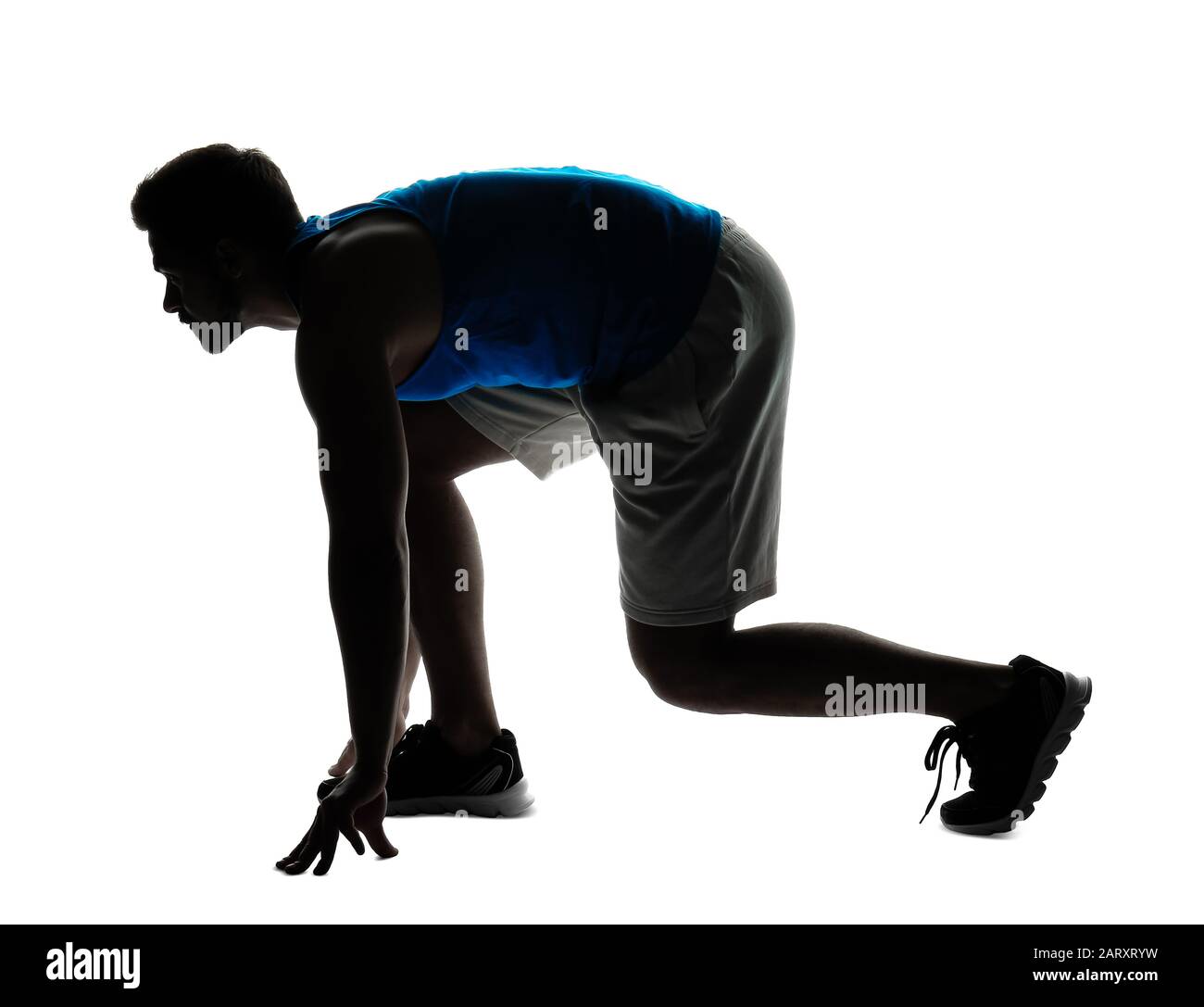 Silhouette of sporty young man in crouch start position on white ...