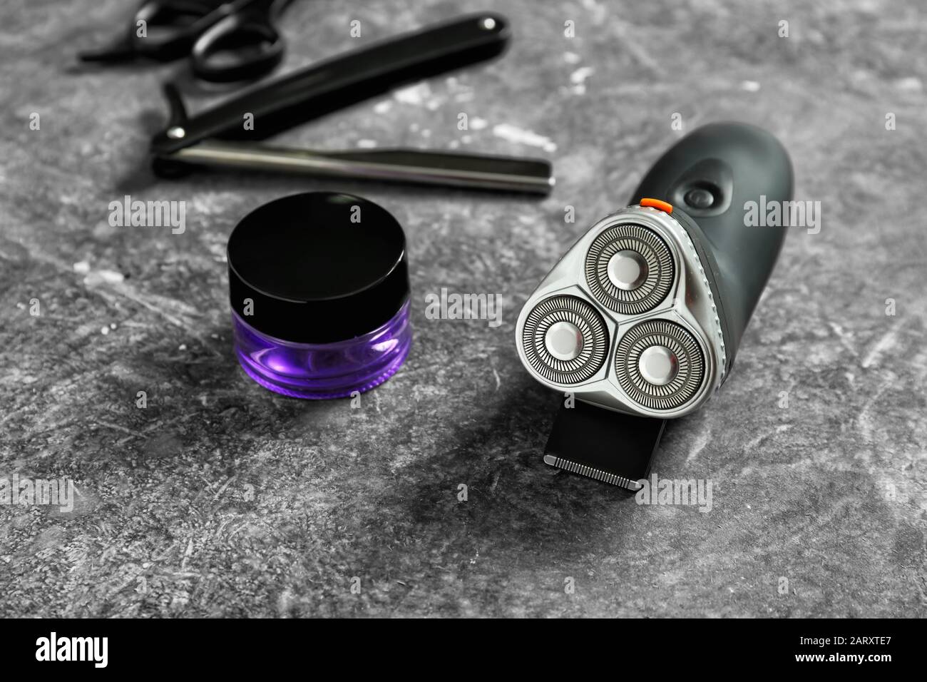 Electric shaver with cosmetics on grey background Stock Photo - Alamy