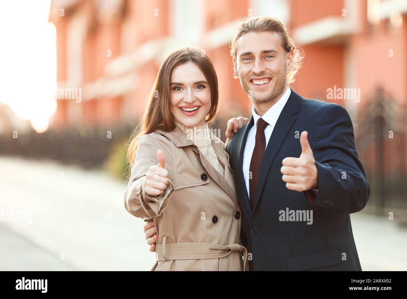 Young couple showing thumb-up gesture near their new house Stock Photo ...
