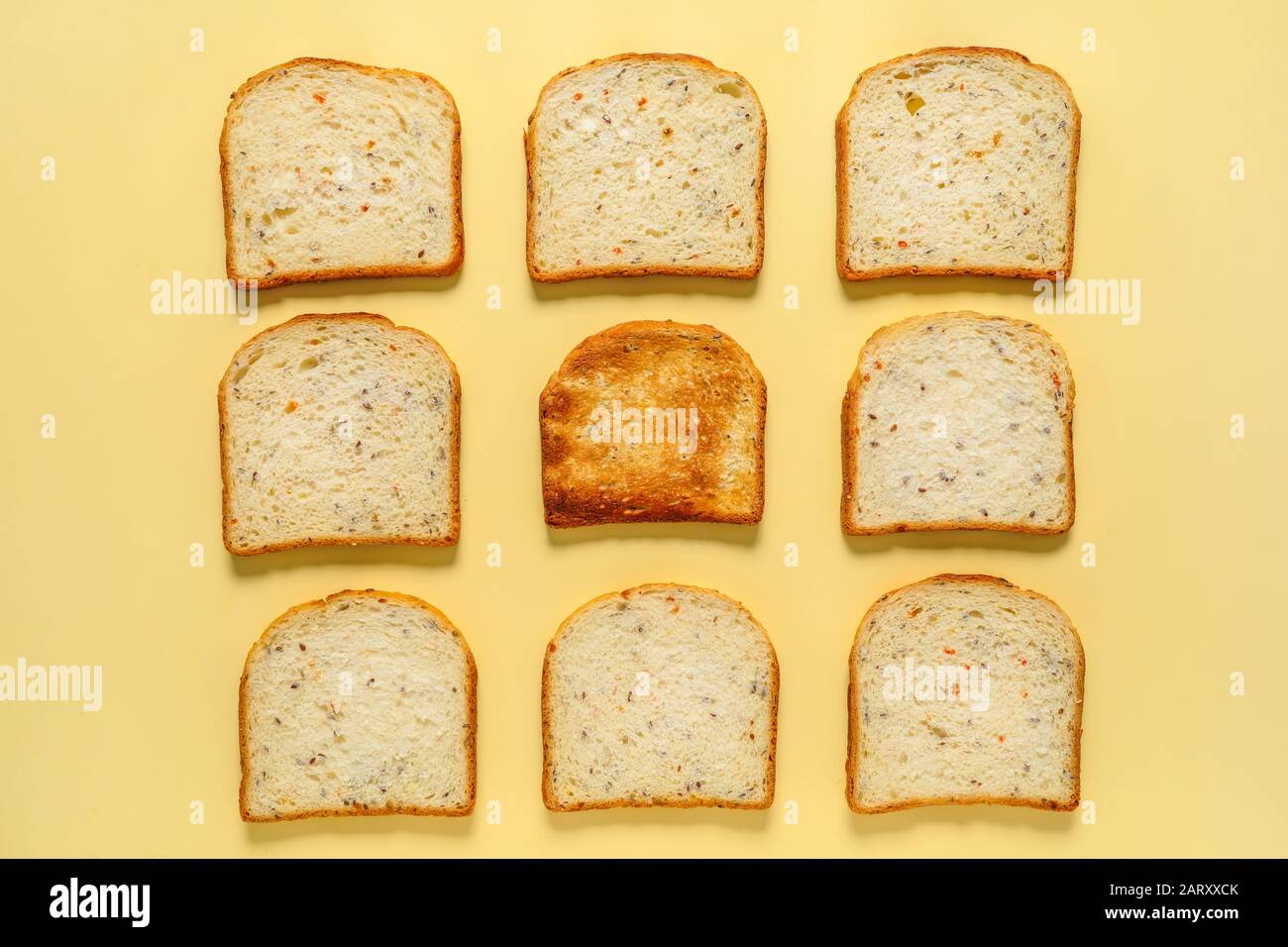 Toasted bread among fresh ones on color background. Concept of ...