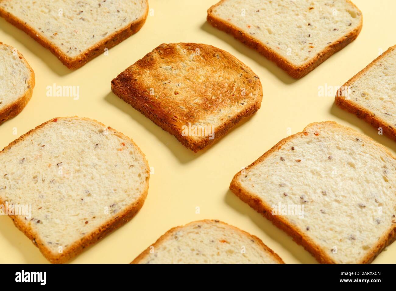 Toasted bread among fresh ones on color background. Concept of ...