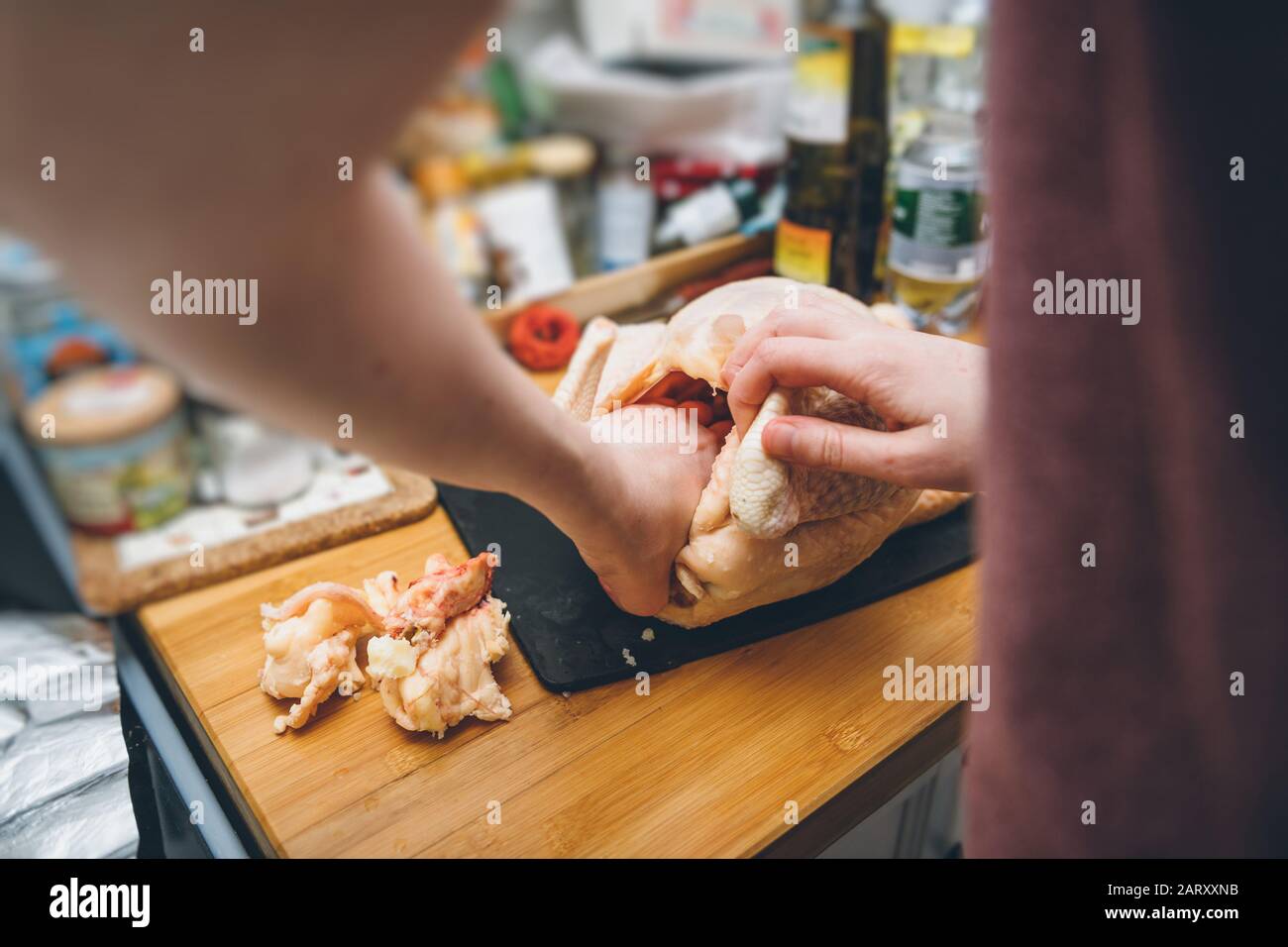 POV Woman removing fat from fresh Capon Chapon cockerel meat on kitchen ...