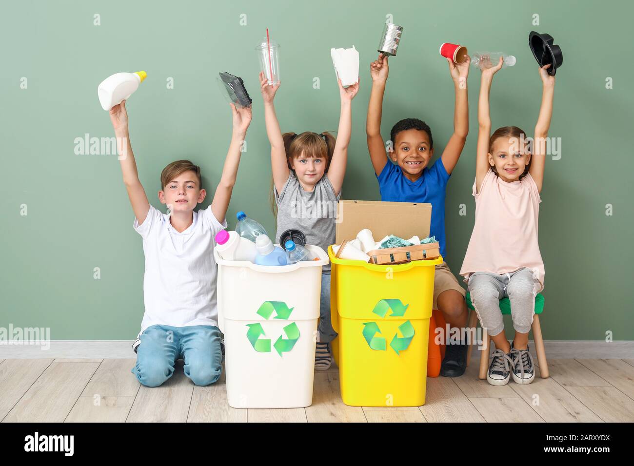 Little children and containers with trash near color wall. Concept of ...
