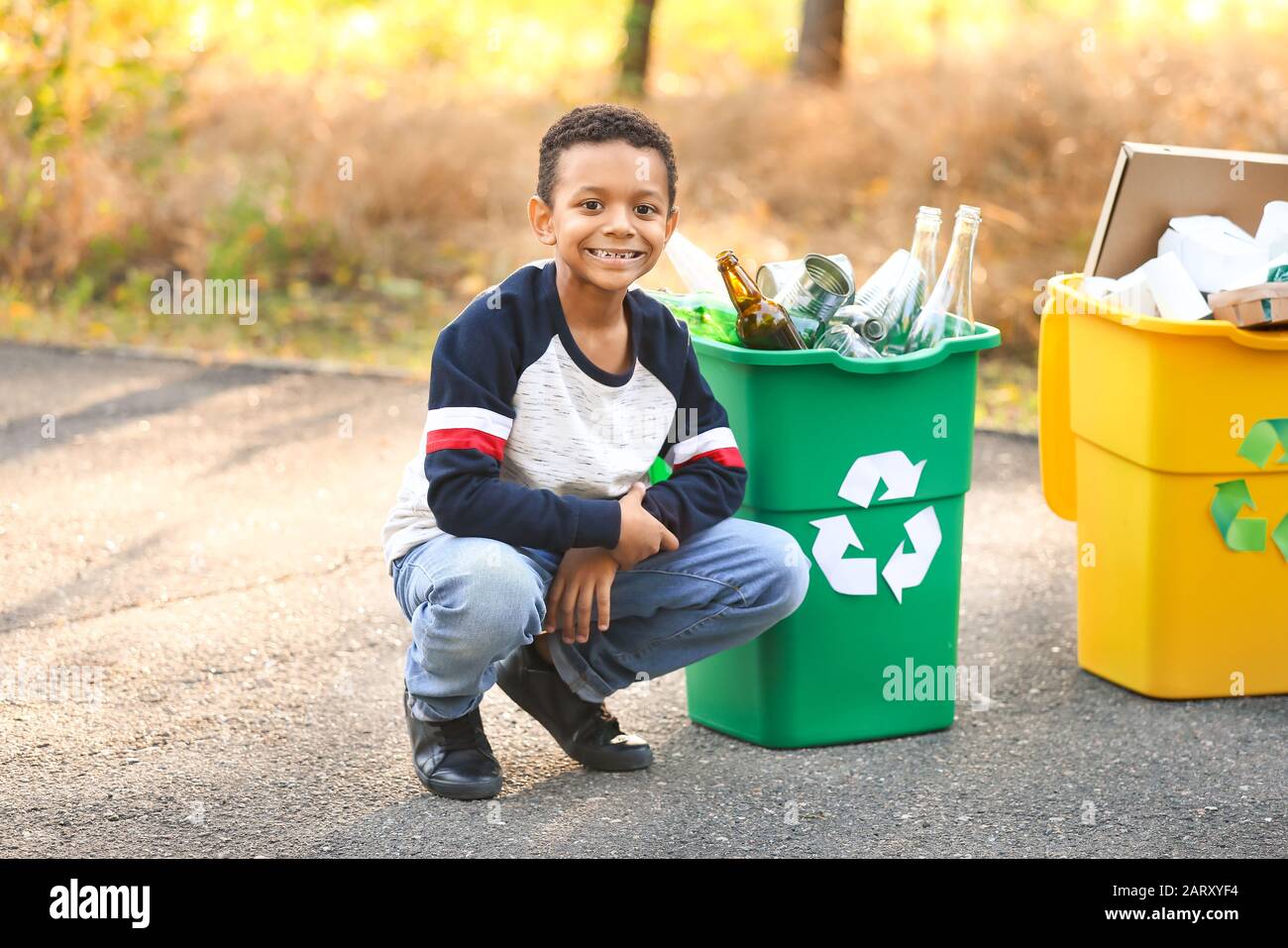 Little African-American boy collecting trash outdoors. Concept of ...