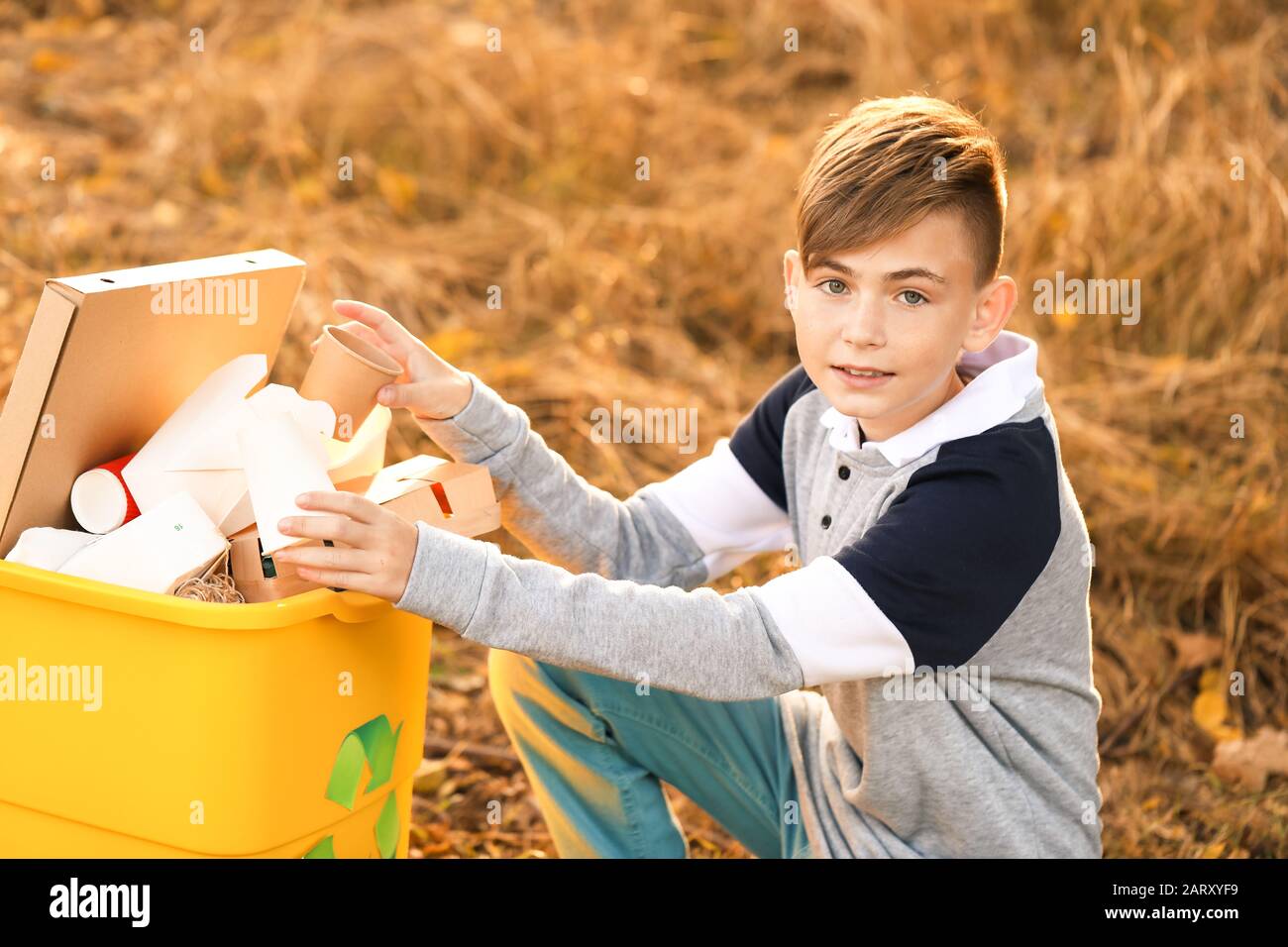Little boy collecting trash outdoors. Concept of recycling Stock Photo ...