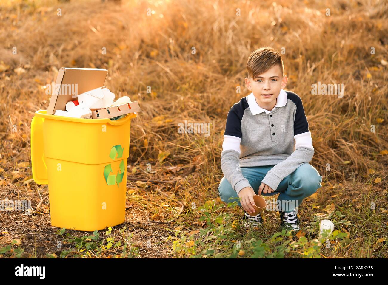 Little boy collecting trash outdoors. Concept of recycling Stock Photo ...