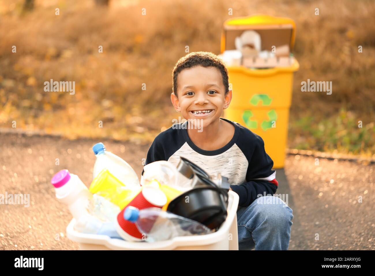 Little African-American boy collecting trash outdoors. Concept of ...