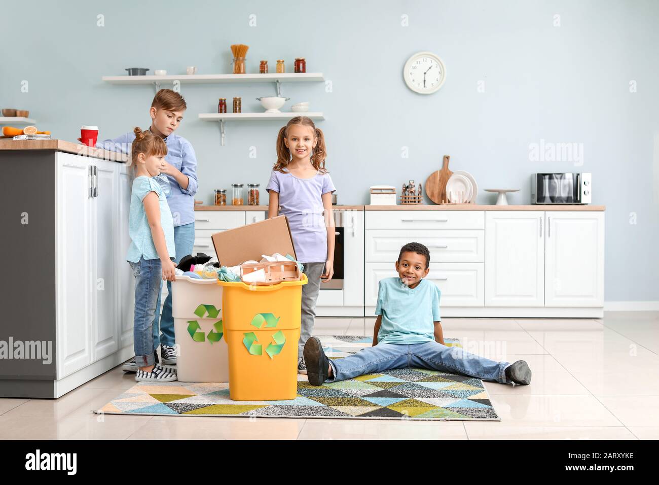 Little children and containers with trash in kitchen. Concept of ...
