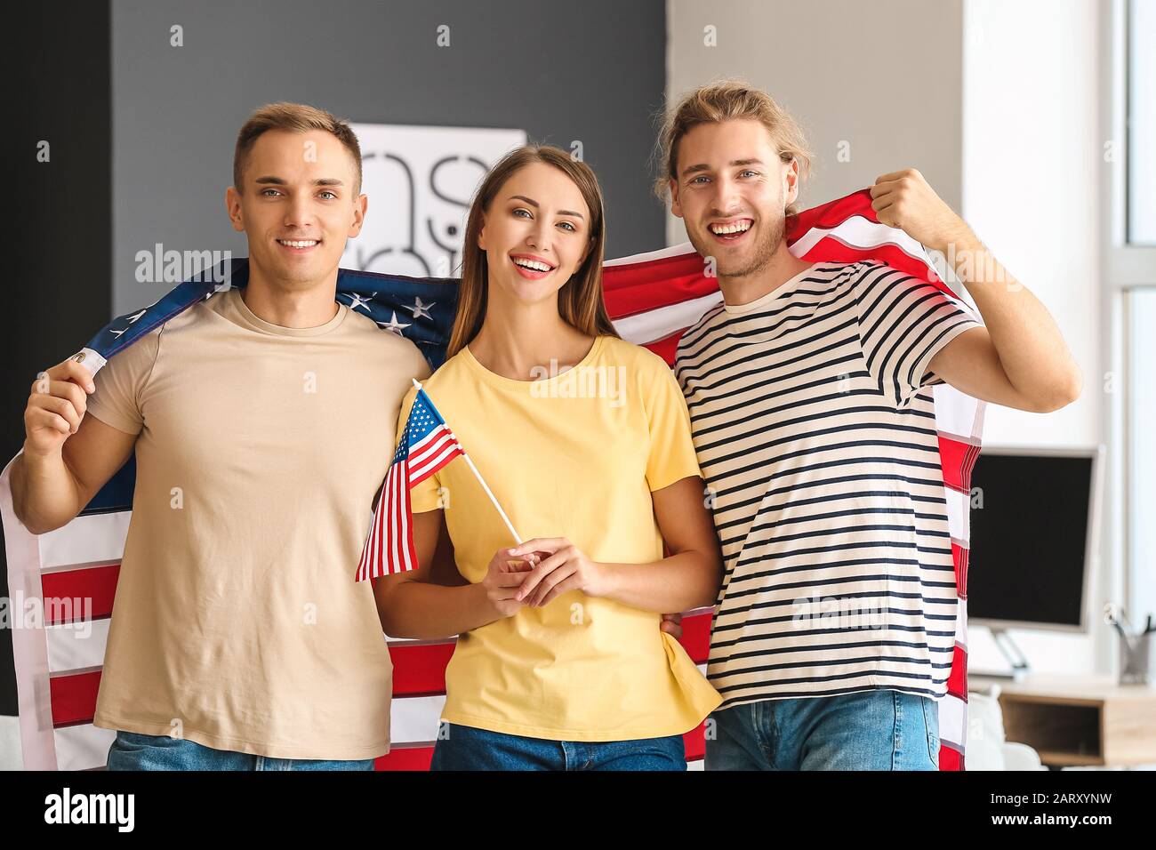 Happy young friends with national flags of USA at home Stock Photo - Alamy