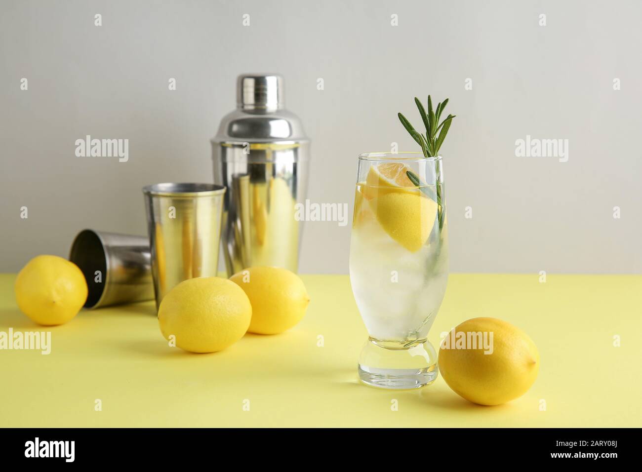 Glass of fresh lemonade and shaker on color table Stock Photo - Alamy