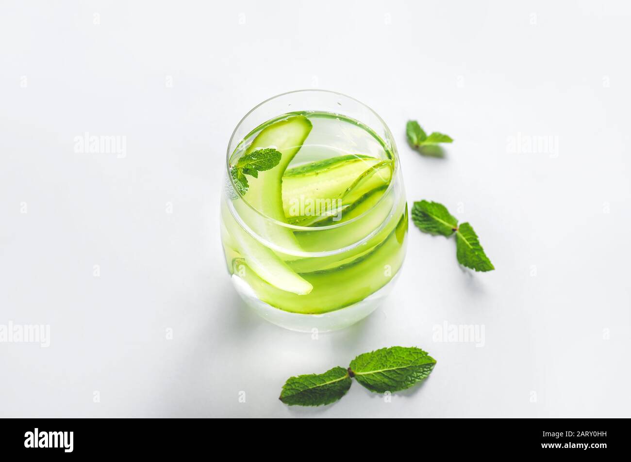 Glass of cold cucumber water on light background Stock Photo - Alamy