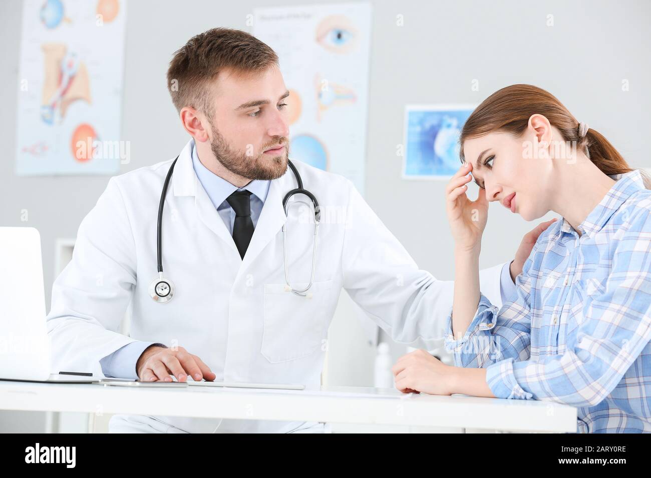 Male doctor calming sad female patient in clinic Stock Photo - Alamy