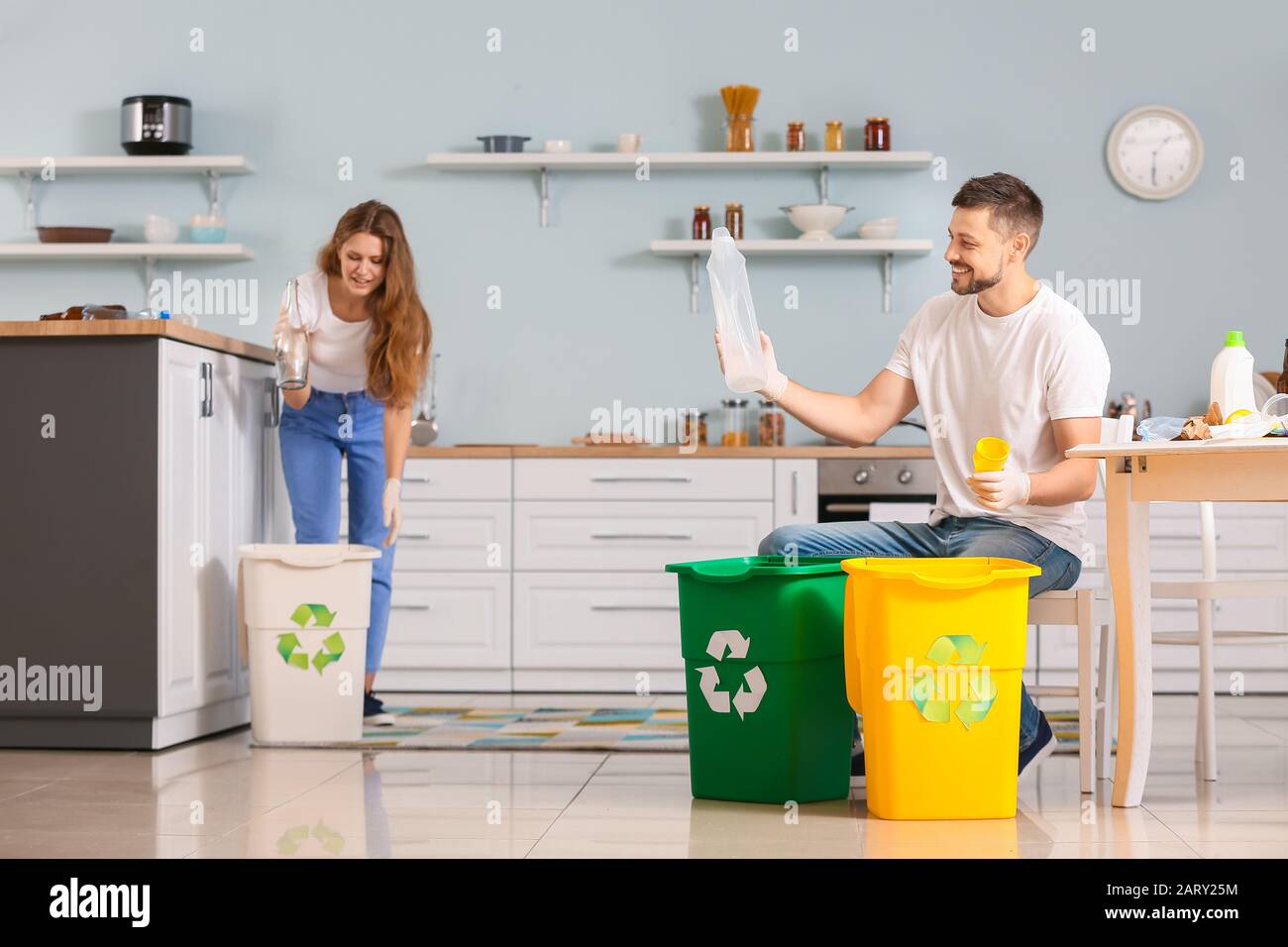 Couple sorting garbage at home. Concept of recycling Stock Photo - Alamy