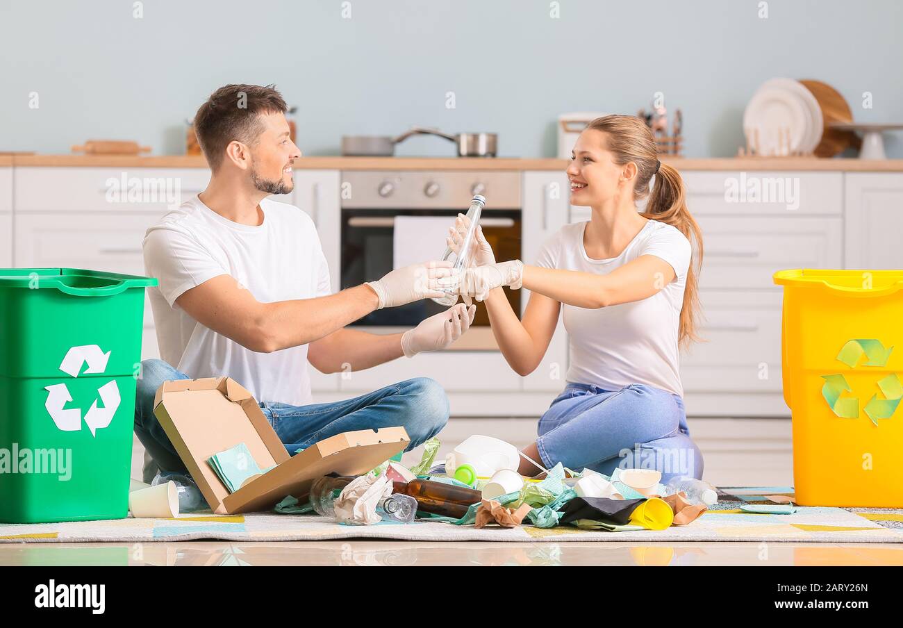 Couple sorting garbage at home. Concept of recycling Stock Photo - Alamy