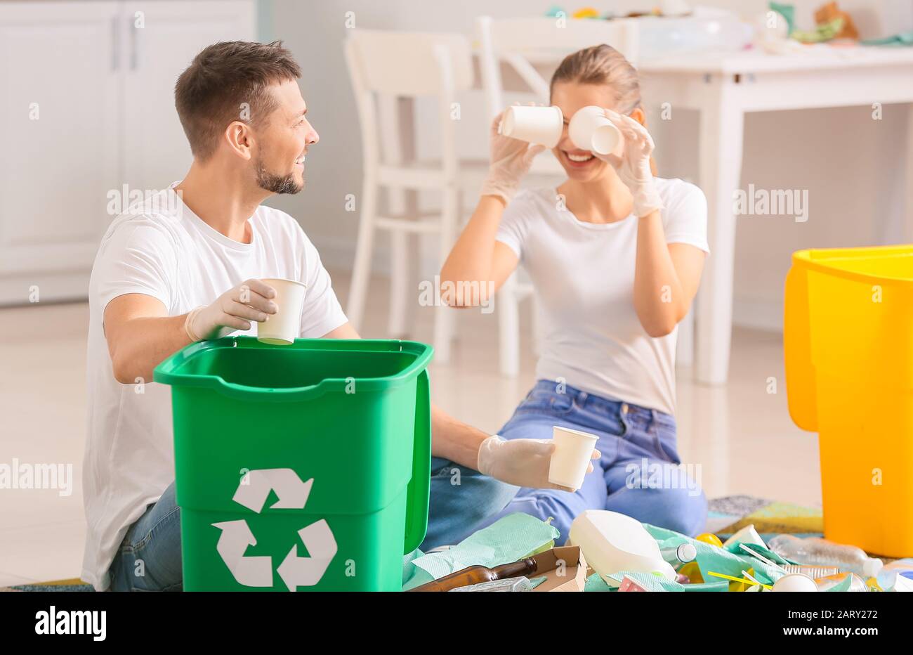 Funny couple sorting garbage at home. Concept of recycling Stock Photo ...