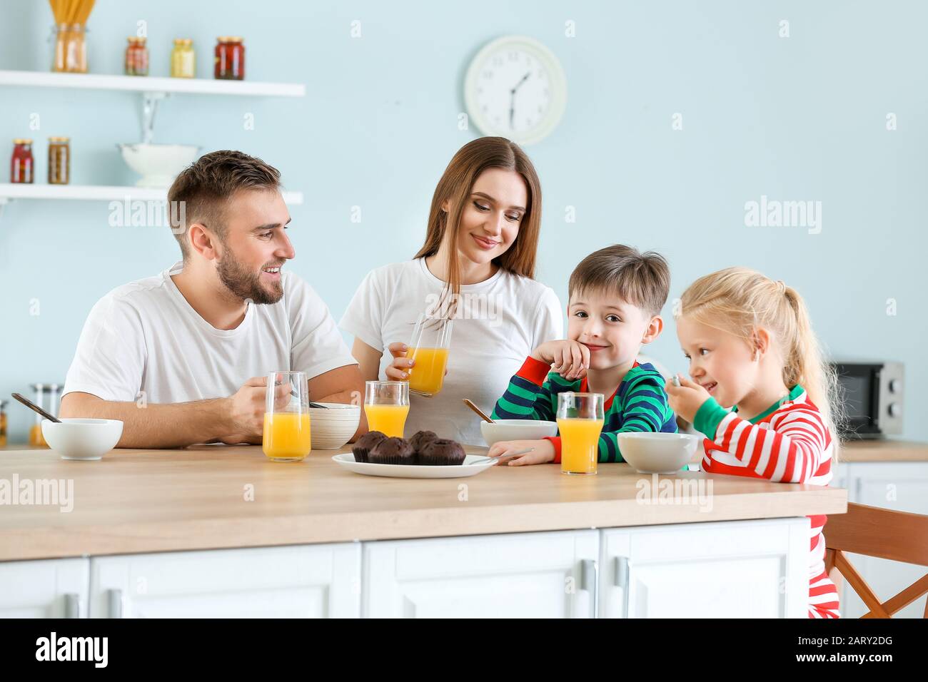 Happy family having lunch in kitchen Stock Photo - Alamy