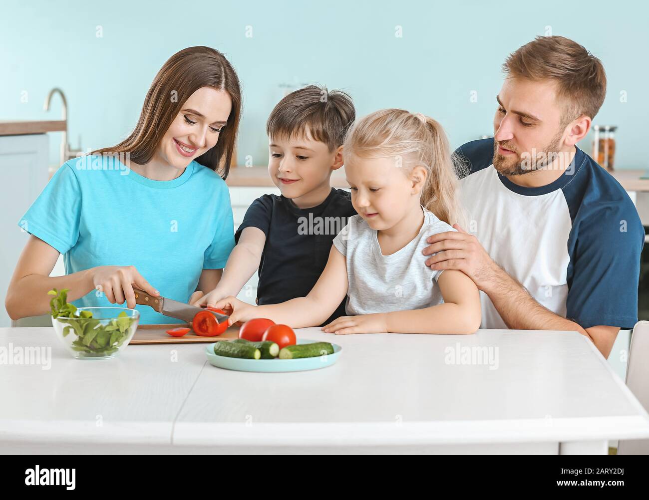 Happy family cooking together in kitchen Stock Photo - Alamy