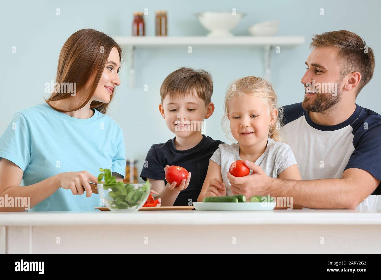 Happy family cooking together in kitchen Stock Photo - Alamy