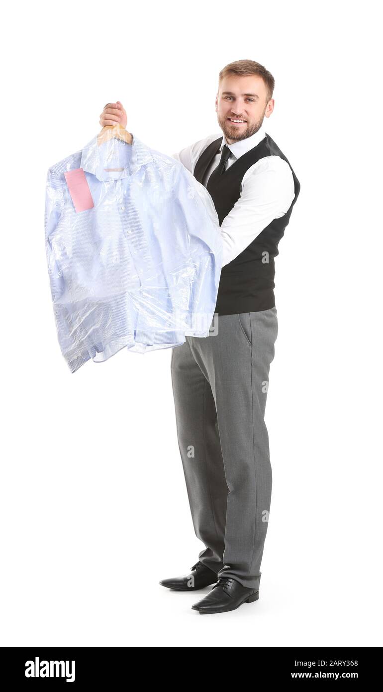 Male worker of modern dry-cleaner's with clothes on white background ...
