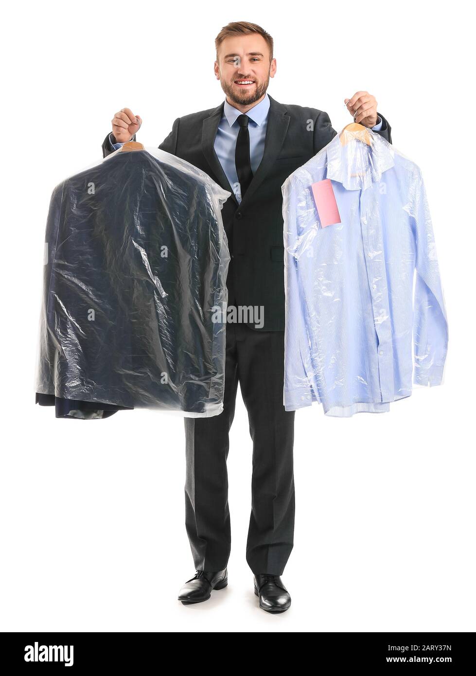 Male worker of modern dry-cleaner's with clothes on white background ...