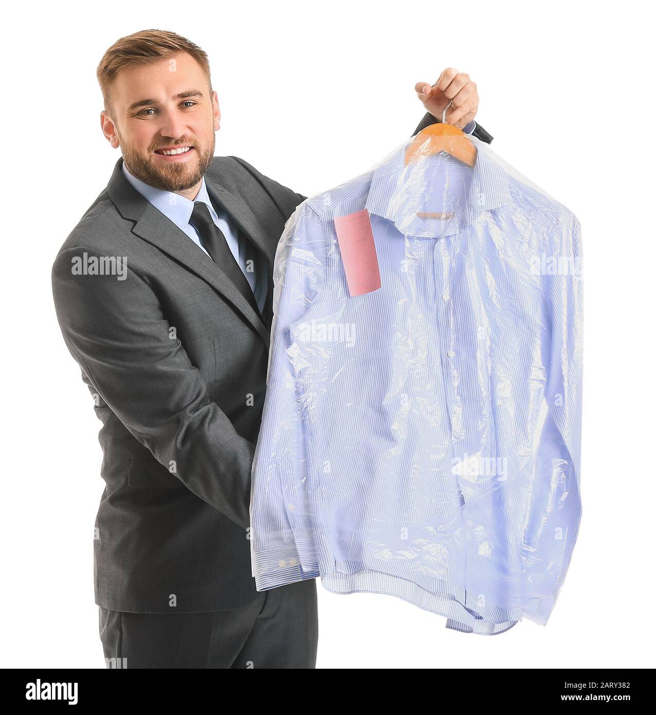 Male worker of modern dry-cleaner's with clothes on white background ...