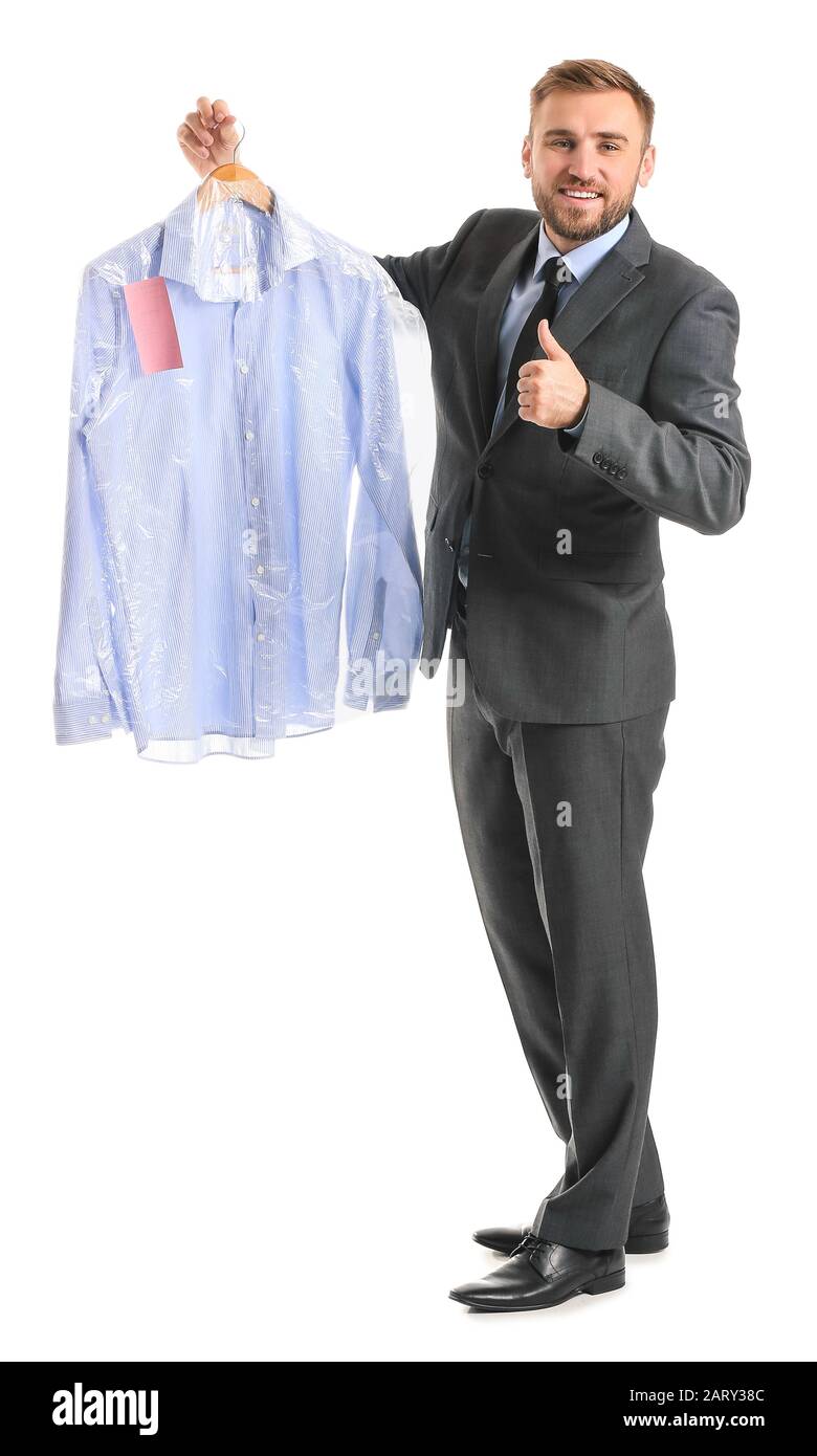 Male worker of modern dry-cleaner's with clothes showing thumb-up on ...