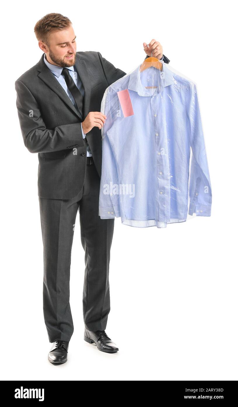 Male worker of modern dry-cleaner's with clothes on white background ...