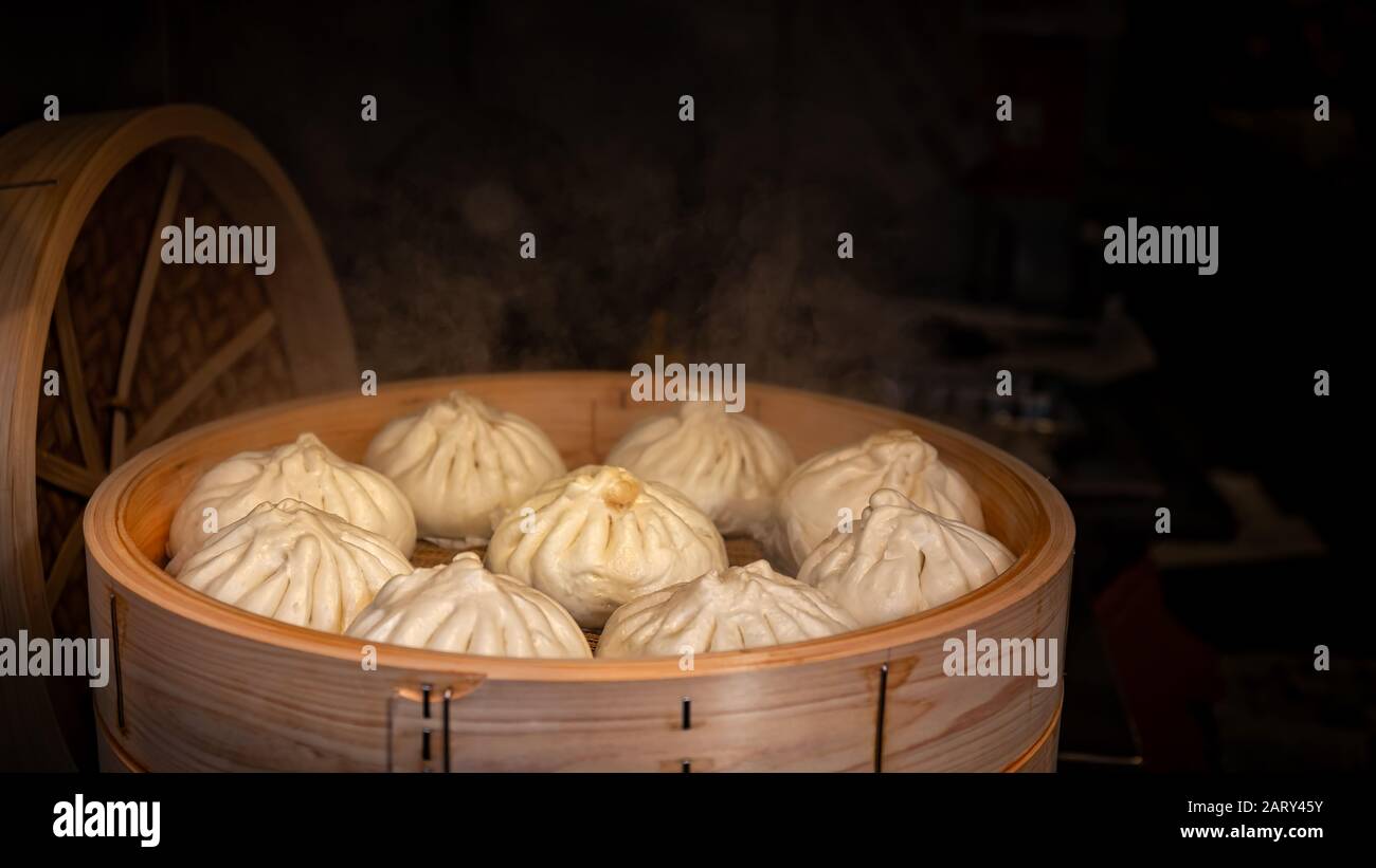 Asian dumplings, called dim sum, cooking in a wooden steamer in ...